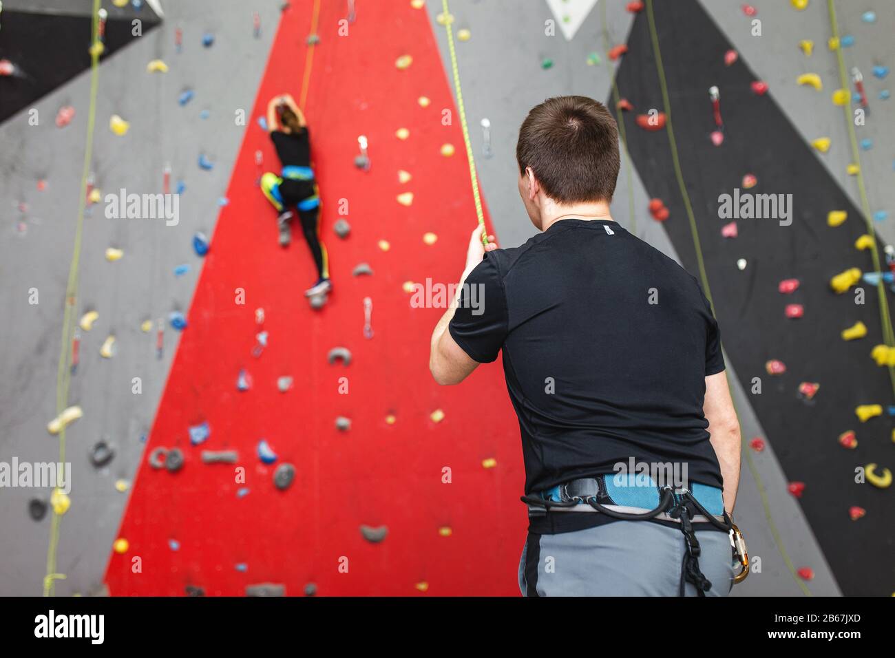 Coach climber belay amateur athlete on a high climbing wall Stock Photo ...