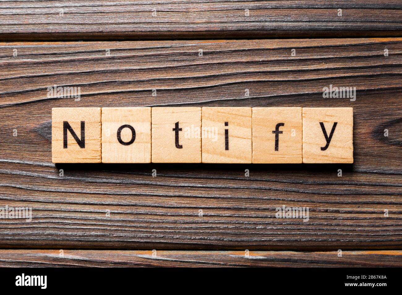 NOTIFY word written on wood block. NOTIFY text on wooden table for your ...