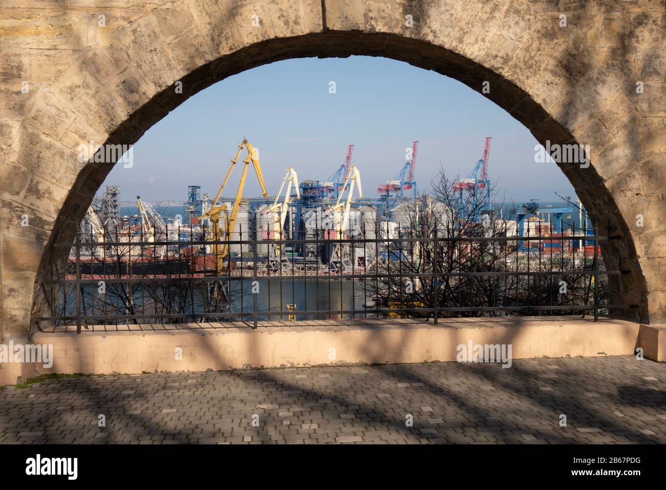 The arch of the ancient fortress wall and the modern seaport in the ...