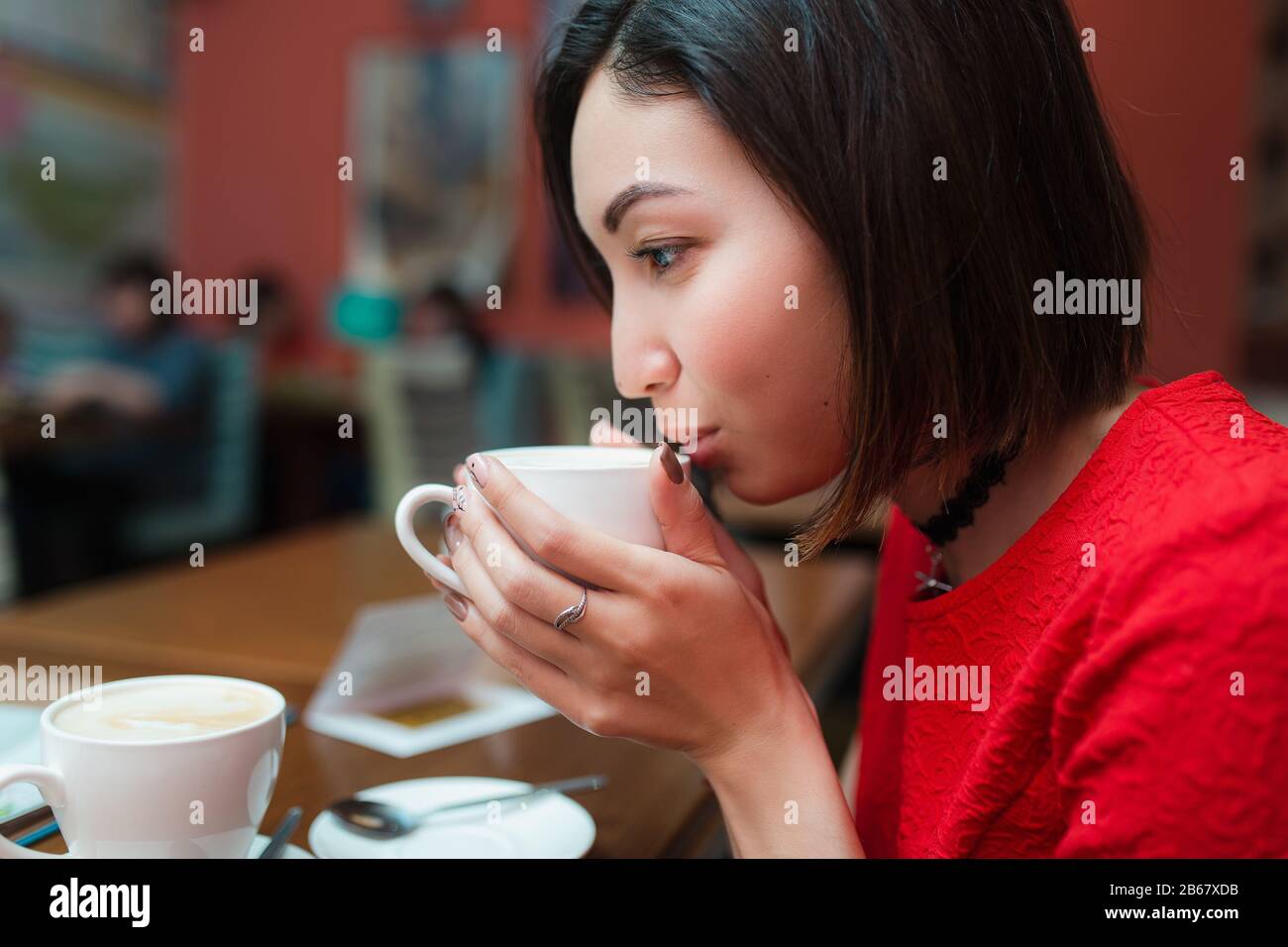 Asian Woman drink a cup of tea or coffee in cafe Stock Photo - Alamy