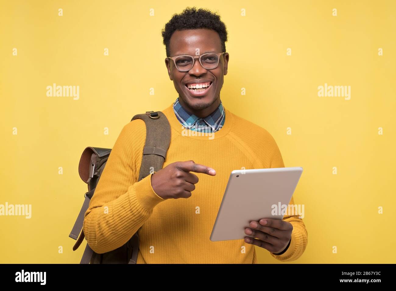 Happy african american college student holding tablet on isolated ...