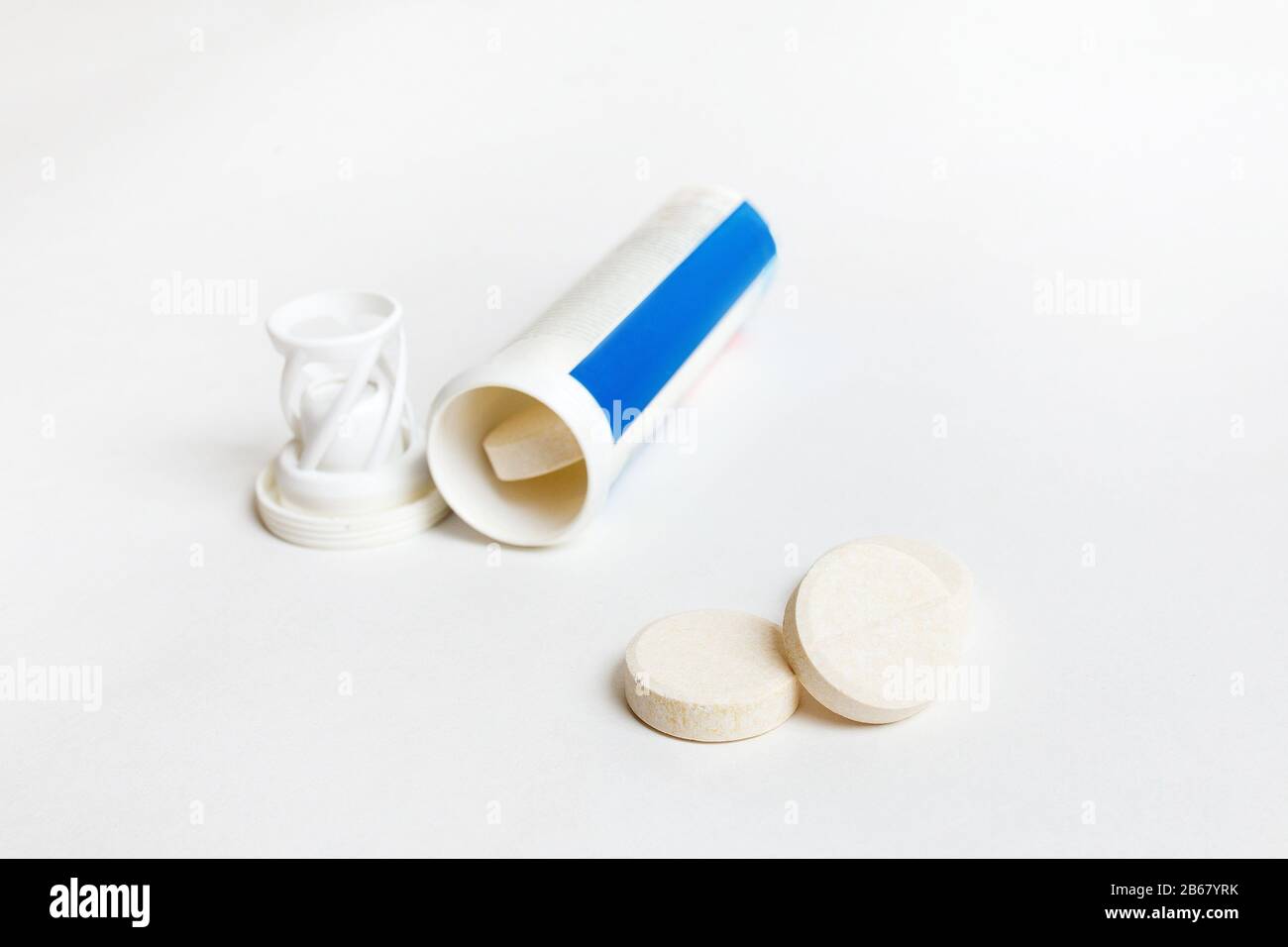 Vial with scattered medication tablets on white Stock Photo - Alamy