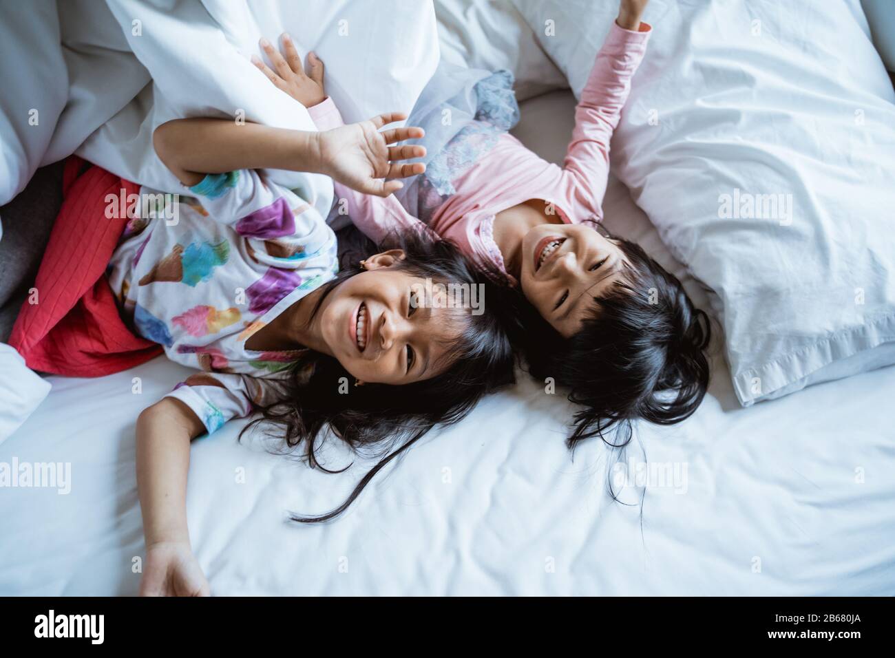 two children play and laugh in bed when they wake up Stock Photo - Alamy