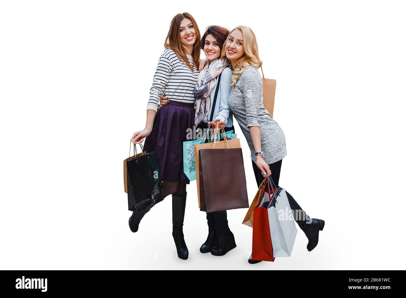 Three happy blonde and brunette girls friends carry their shopping bags ...