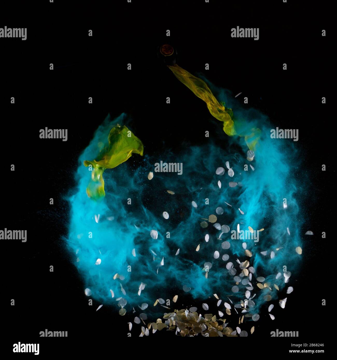 Bursting balloon full of coloured powder and glitter on a black ...