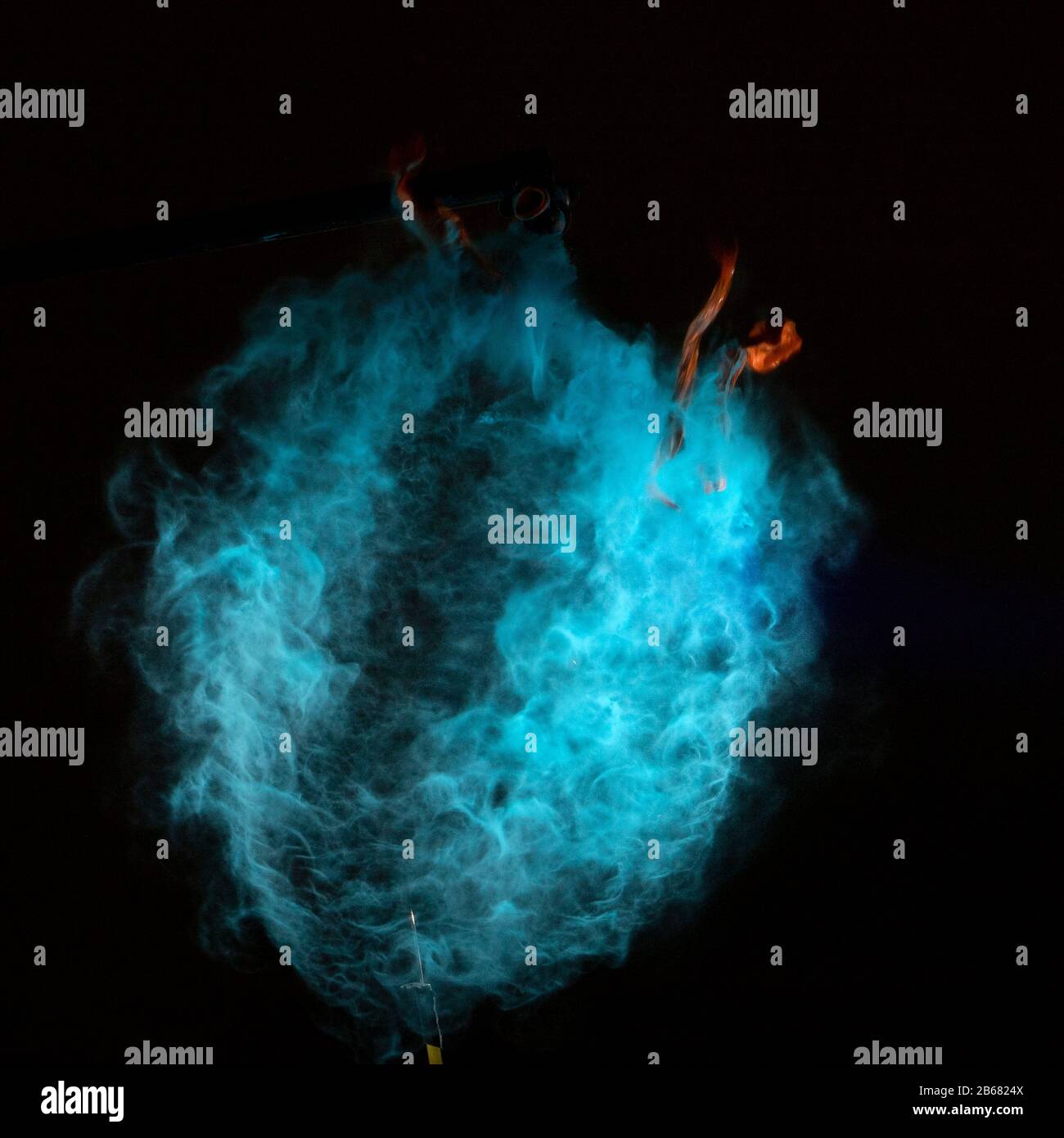 Bursting balloon full of coloured powder and glitter on a black ...