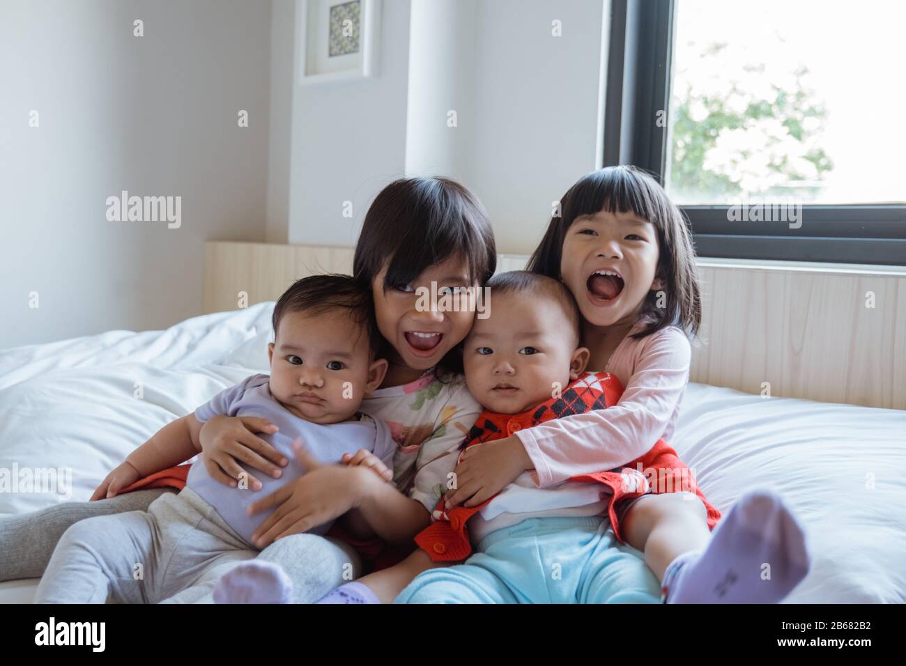 four children happy to play and joke in bed when they wake up Stock ...
