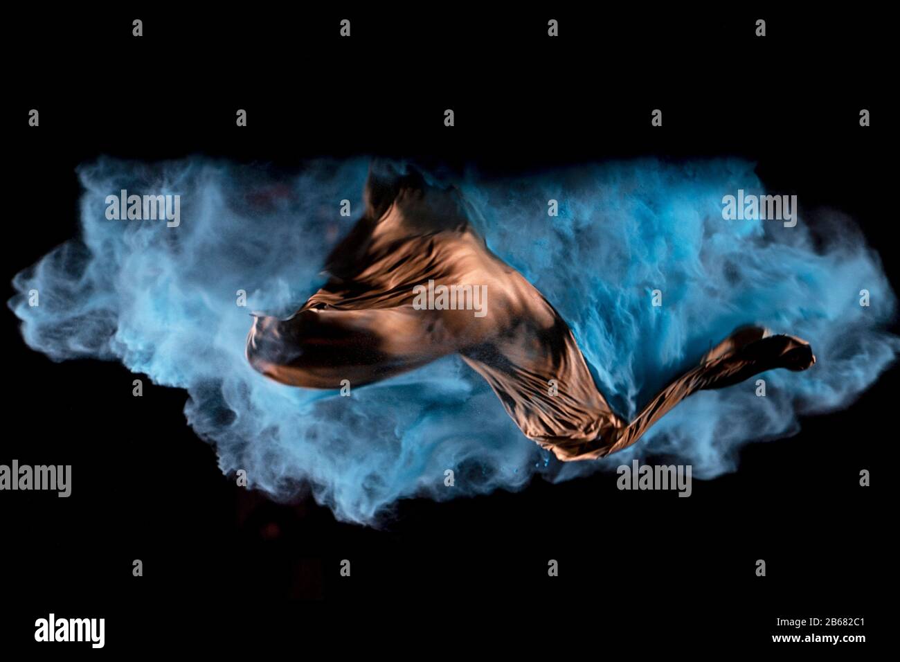 Bursting balloon full of coloured powder and glitter on a black ...