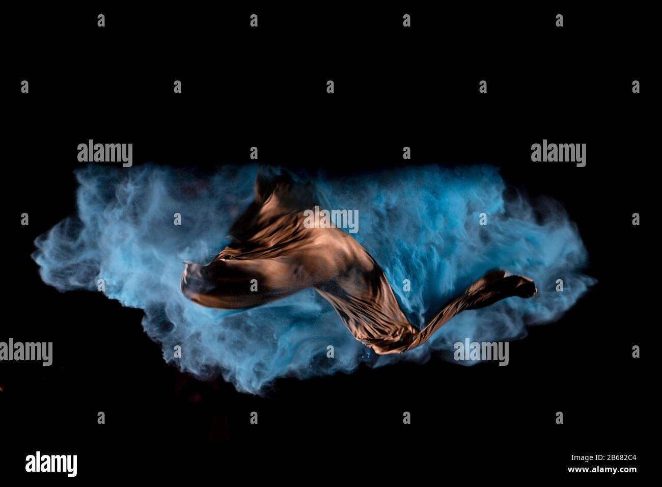 Bursting balloon full of coloured powder and glitter on a black ...