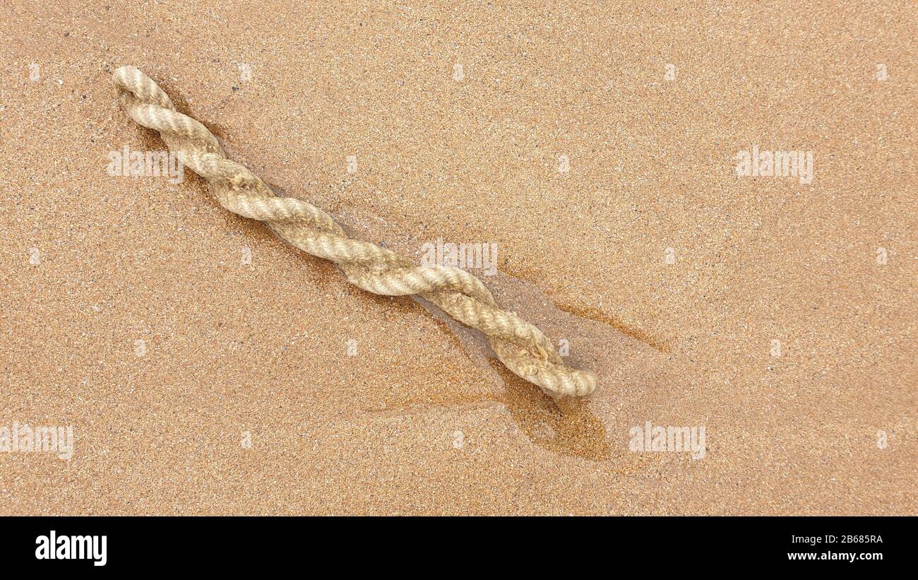 Rope on sand Stock Photo - Alamy