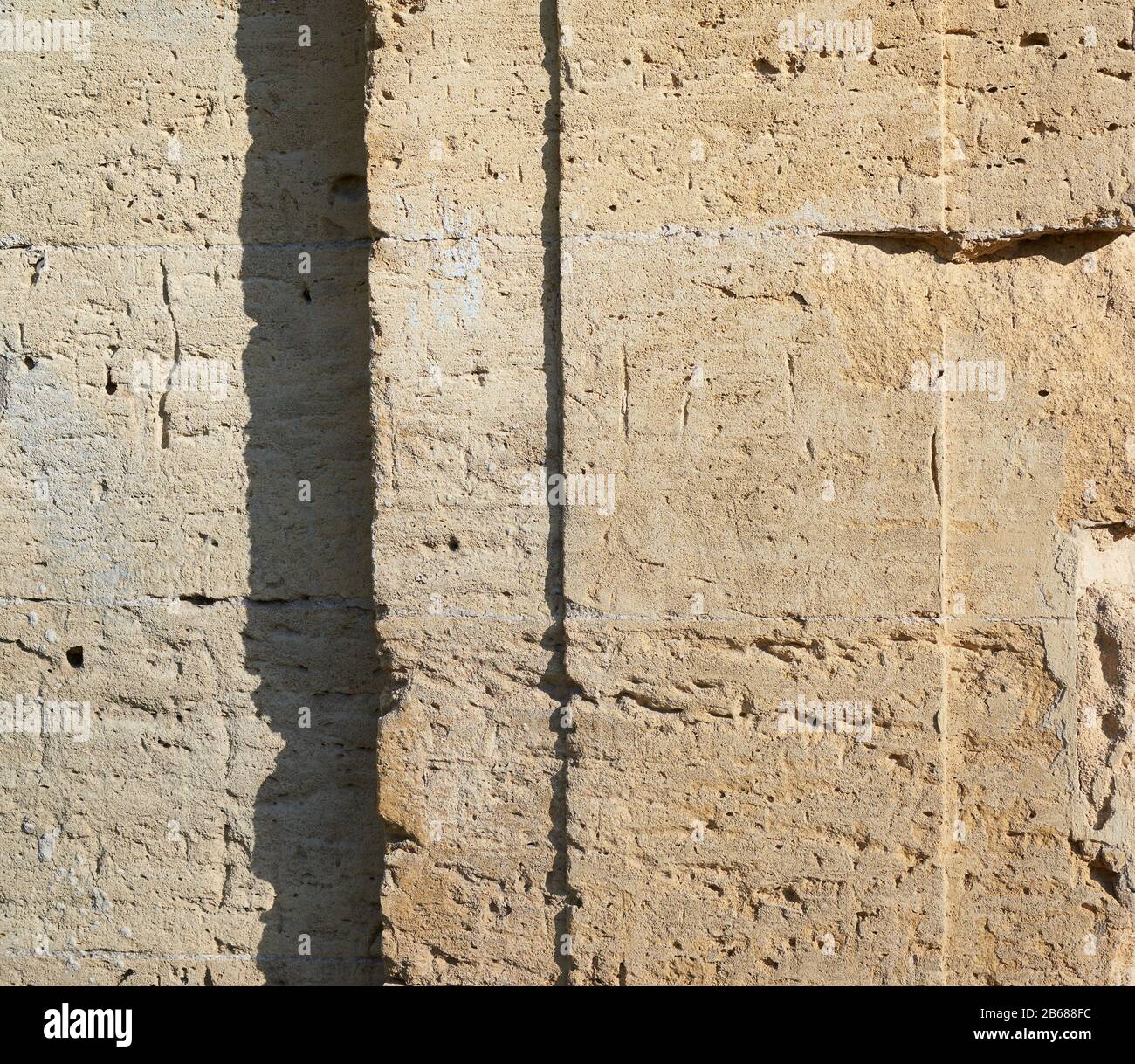 wall of yellow rectangular stones with cement, fragment of ancient ...