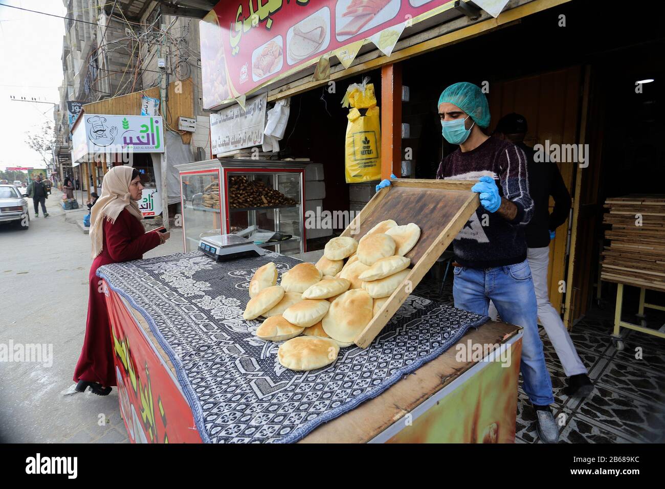 Palestinian workers wearing masks amid coronavirus precautions, bake ...