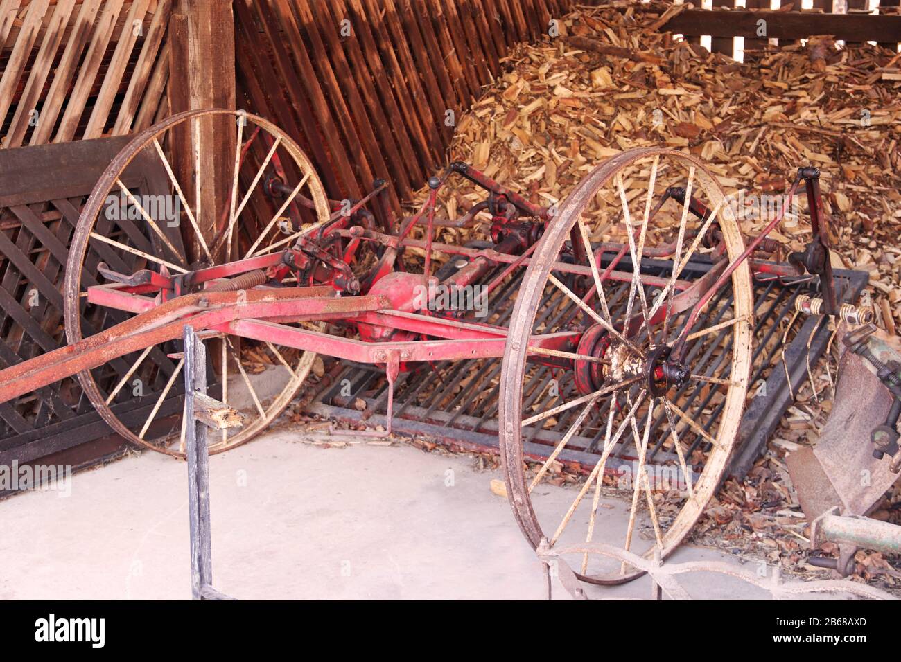 old rusty agricultural machine standing in a woodshed with wood chaff ...