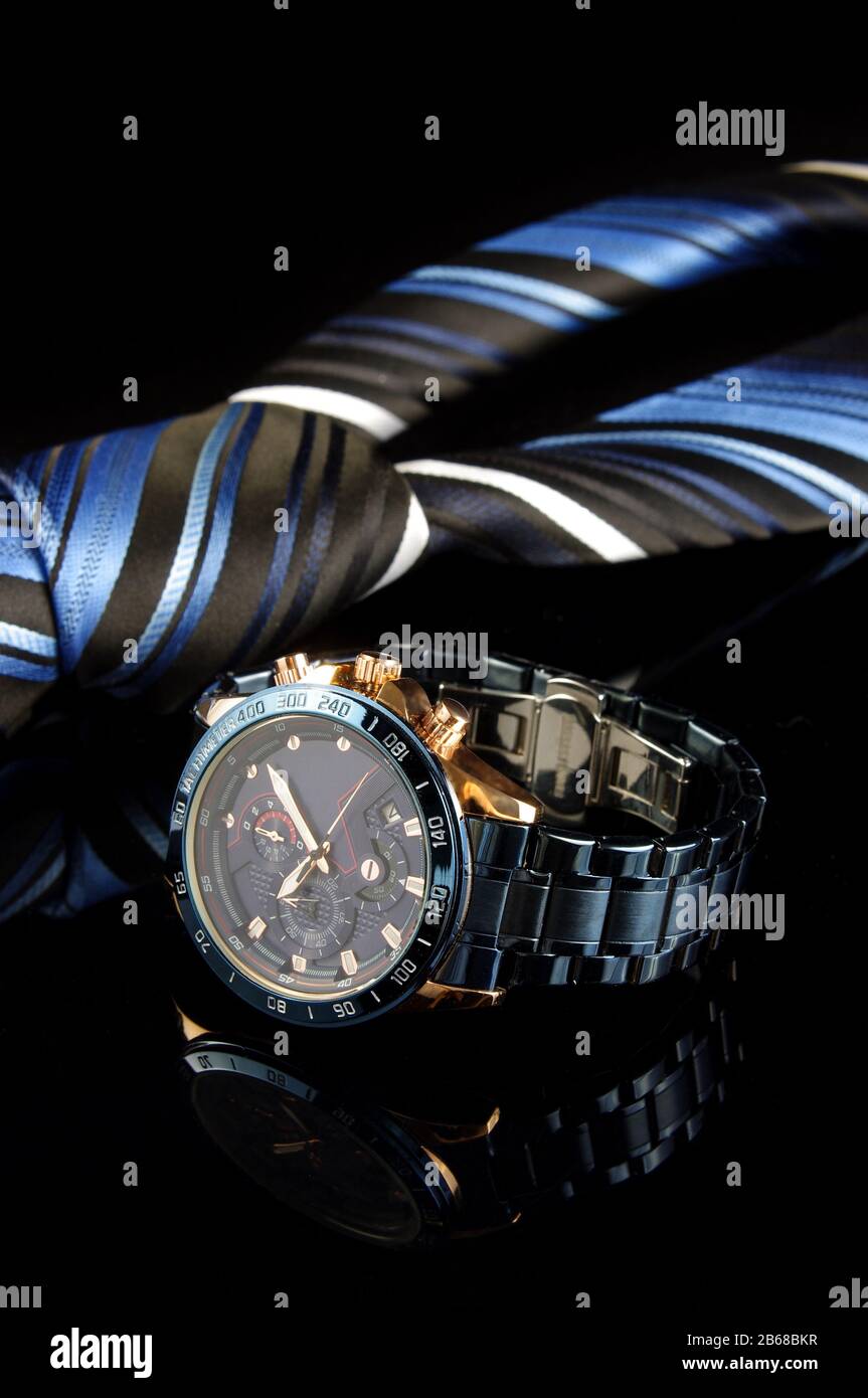 Professional luxury golden blue male watch on the black reflective ...