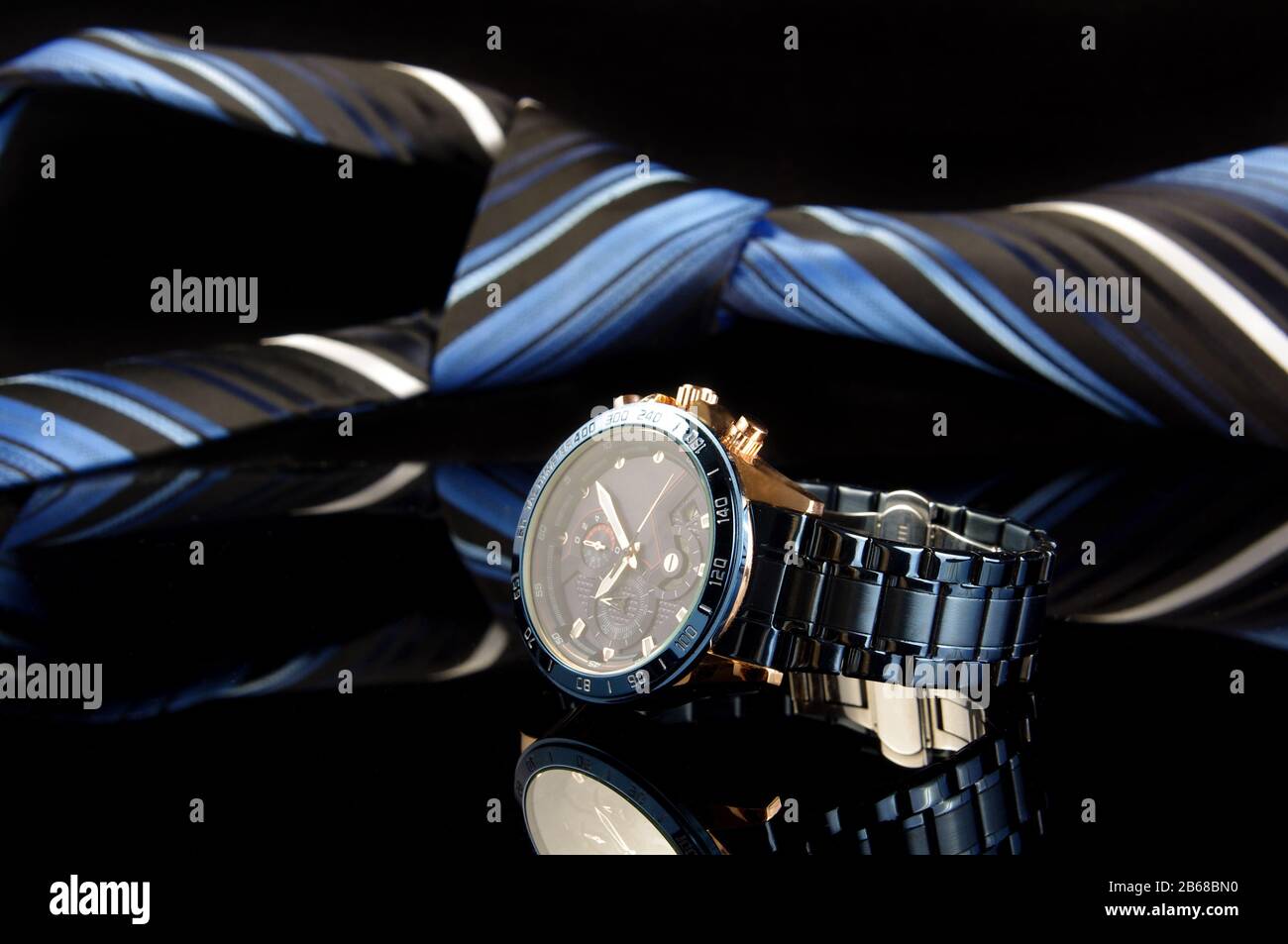 Professional luxury golden blue male watch on the black reflective ...