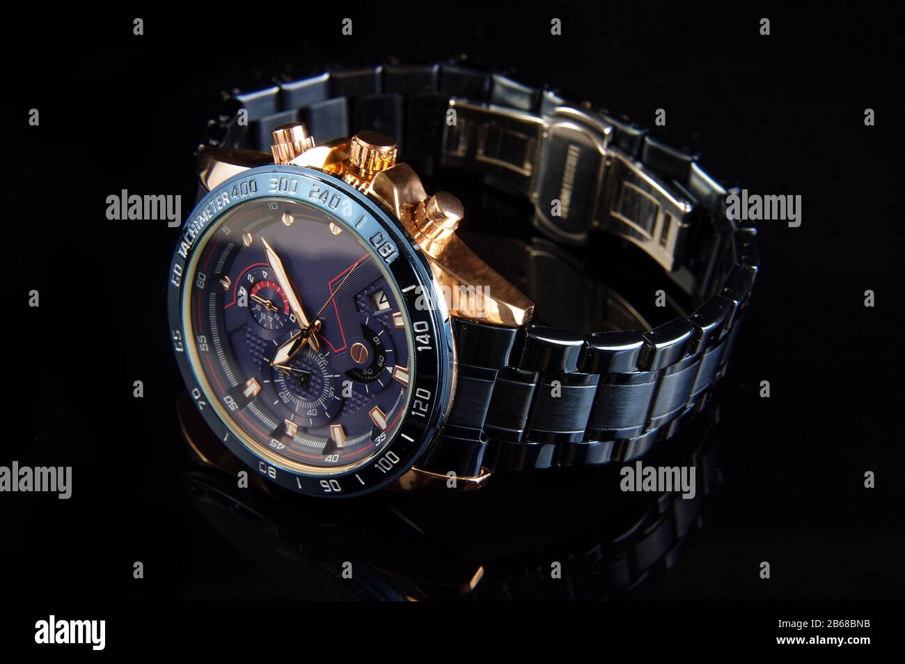 Professional luxury golden blue male watch on the black reflective ...