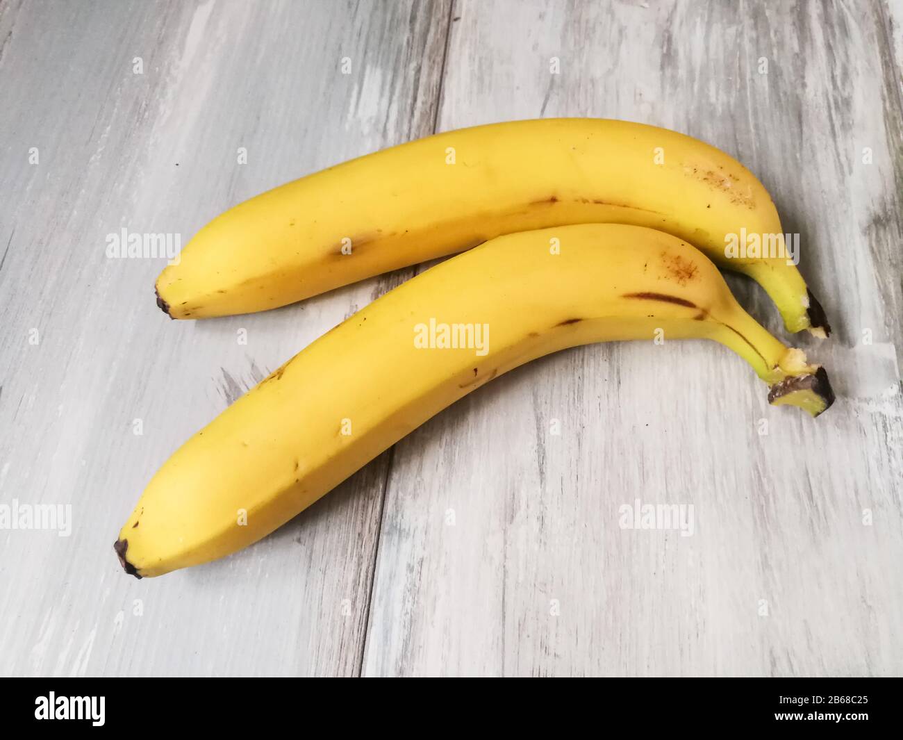 Two organic bananas close up on the reclaimed wood background Stock ...