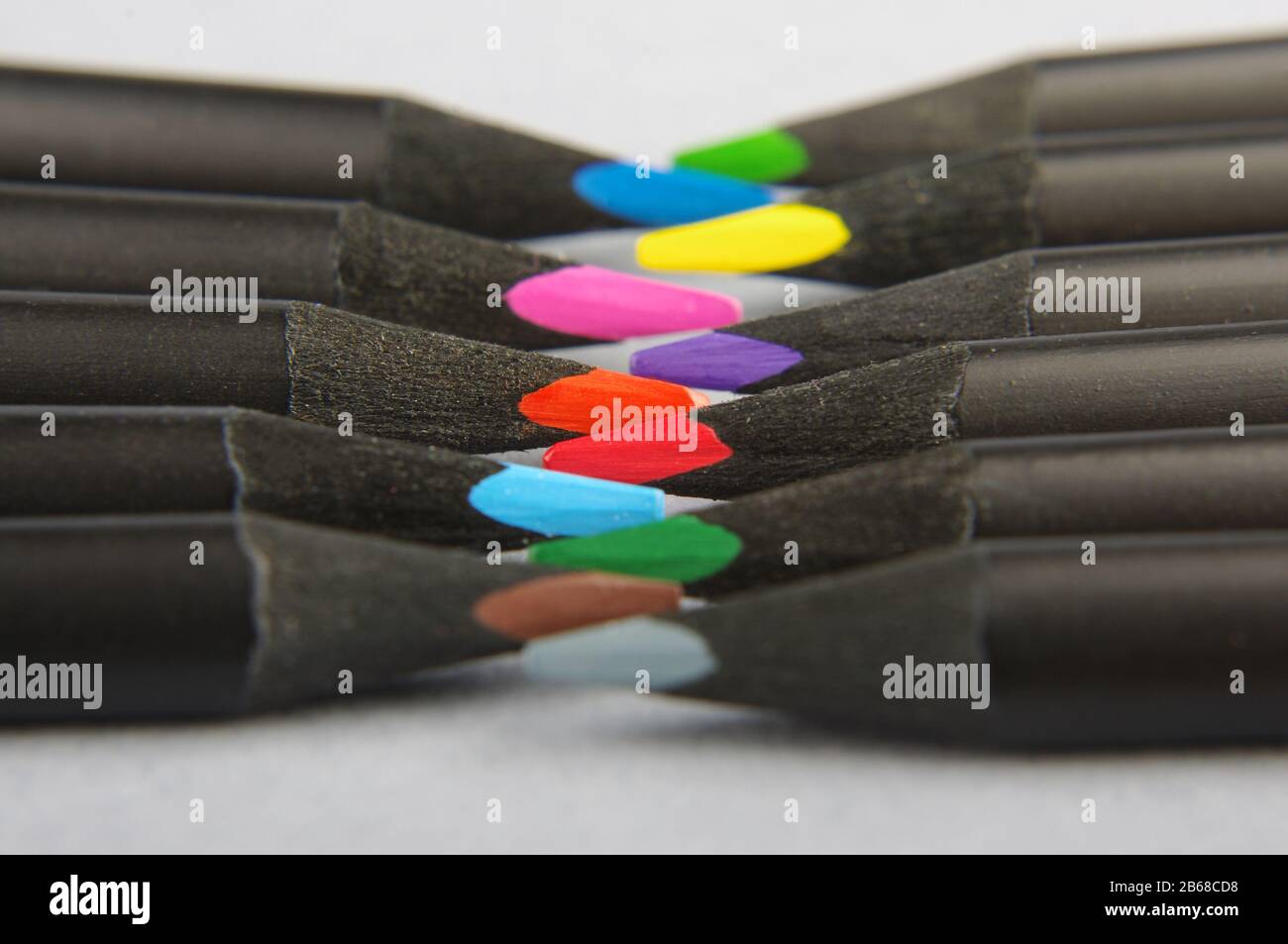 Variety of color pencils arranged in the row on the gray background ...
