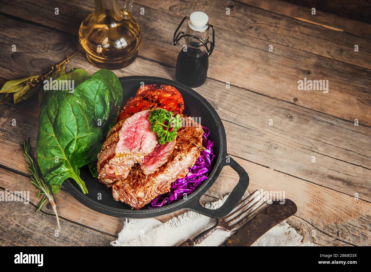 medium beef steak with blood and vegetables on a wooden table. Copy ...
