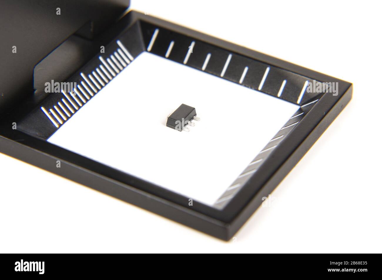 Tiny surface mount SMT electronics chip component close to metal ruler ...
