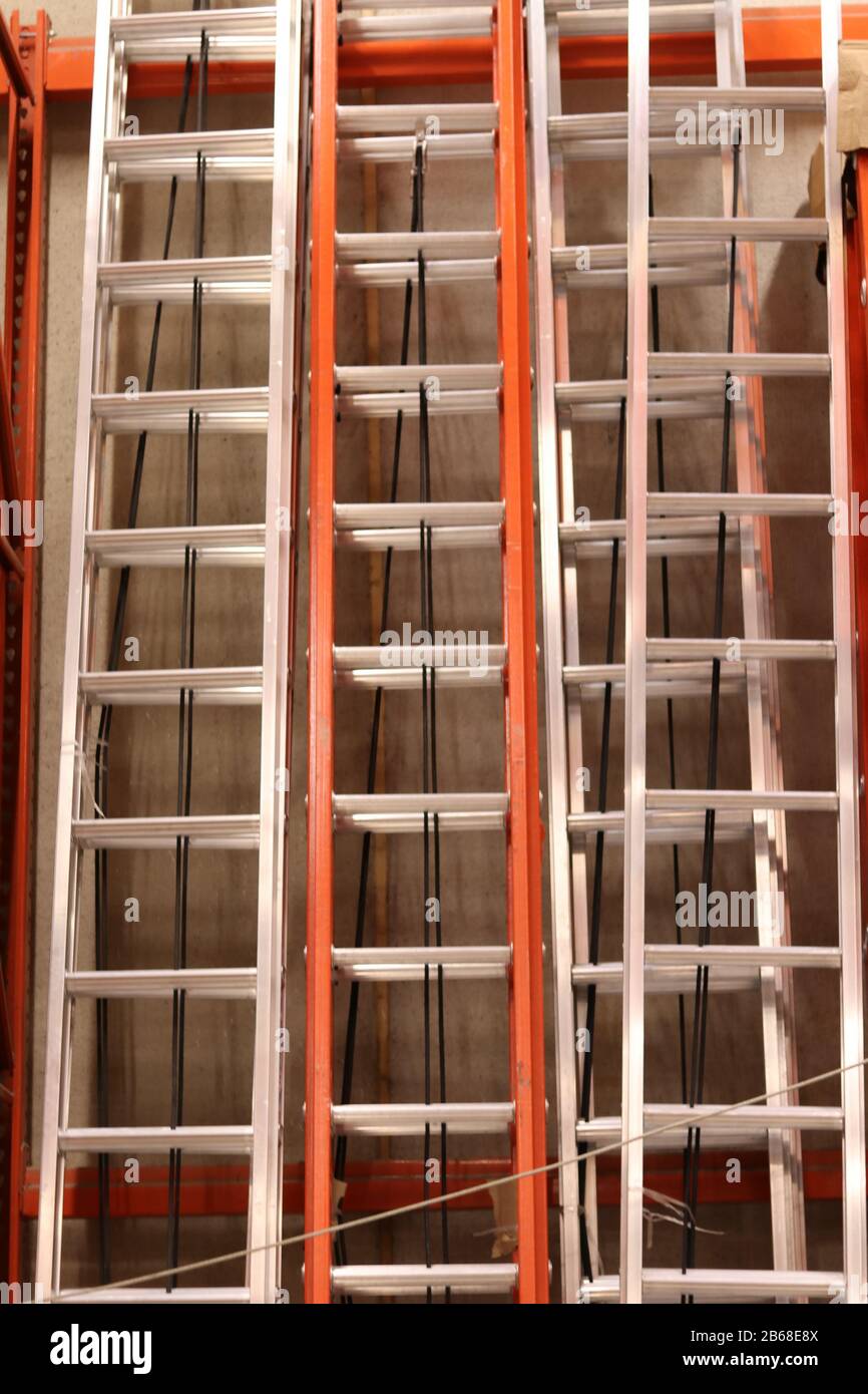 The ladders are lined up against the wall Stock Photo - Alamy