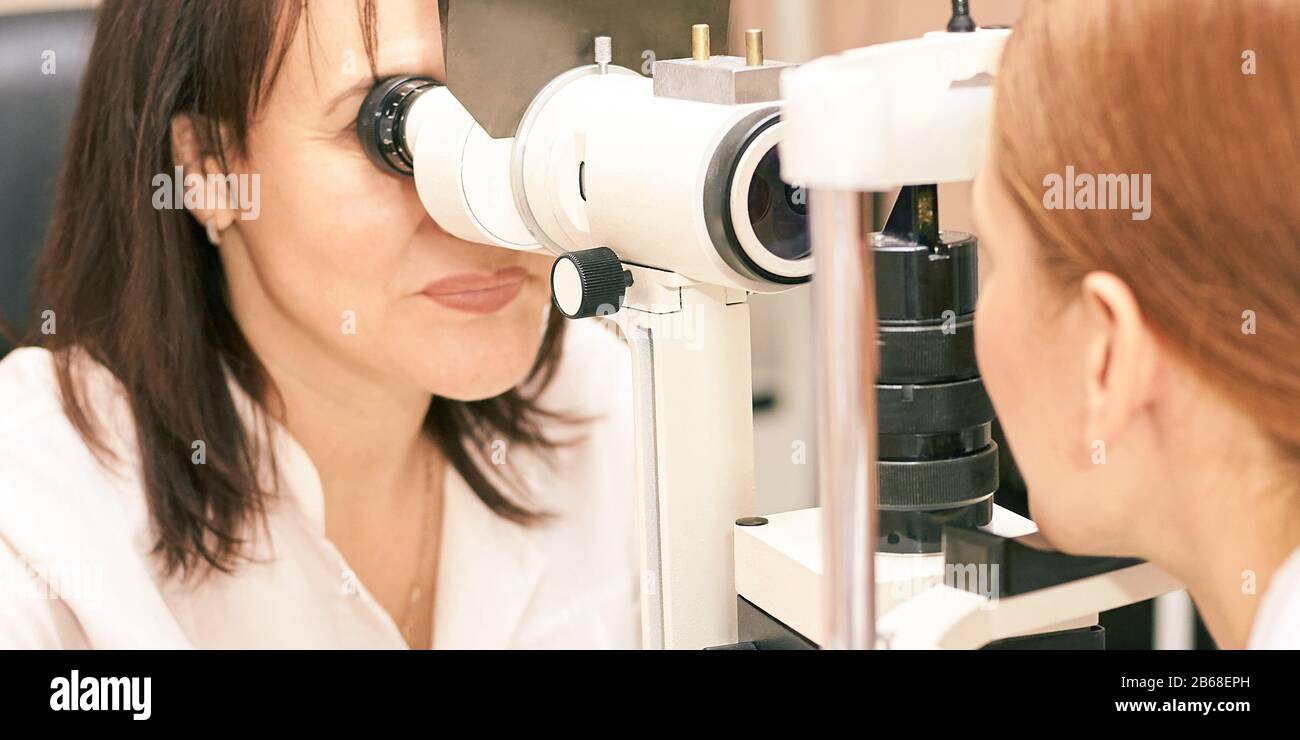 ophthalmologist doctor in exam optician laboratory with female patient ...