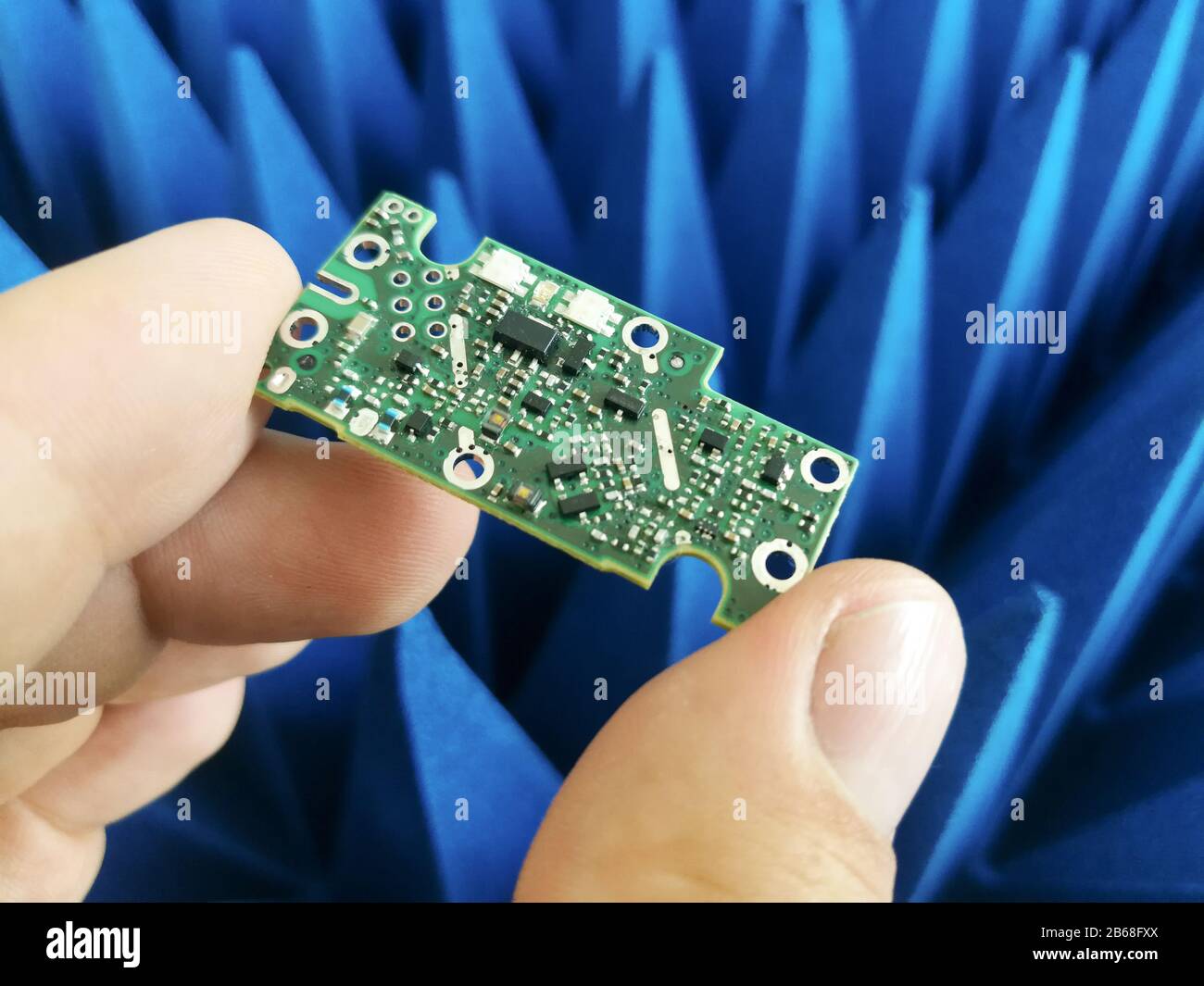 Electronics engineer hand holding printed circuit board in front of ...