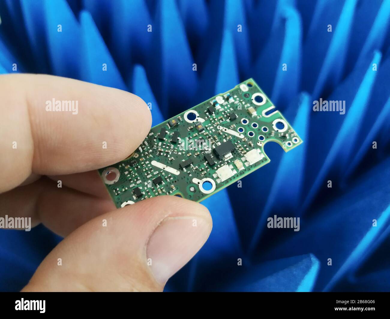 Electronics engineer hand holding printed circuit board in front of ...
