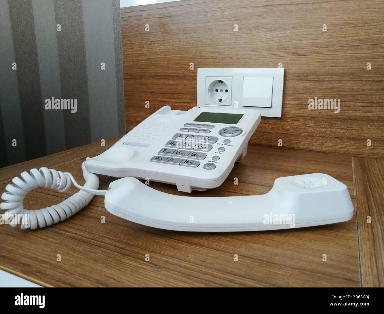 Landline telephone on the wooden office desk. Communication technology ...