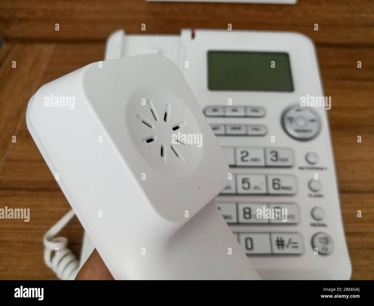 Landline telephone on the wooden office desk. Communication technology ...