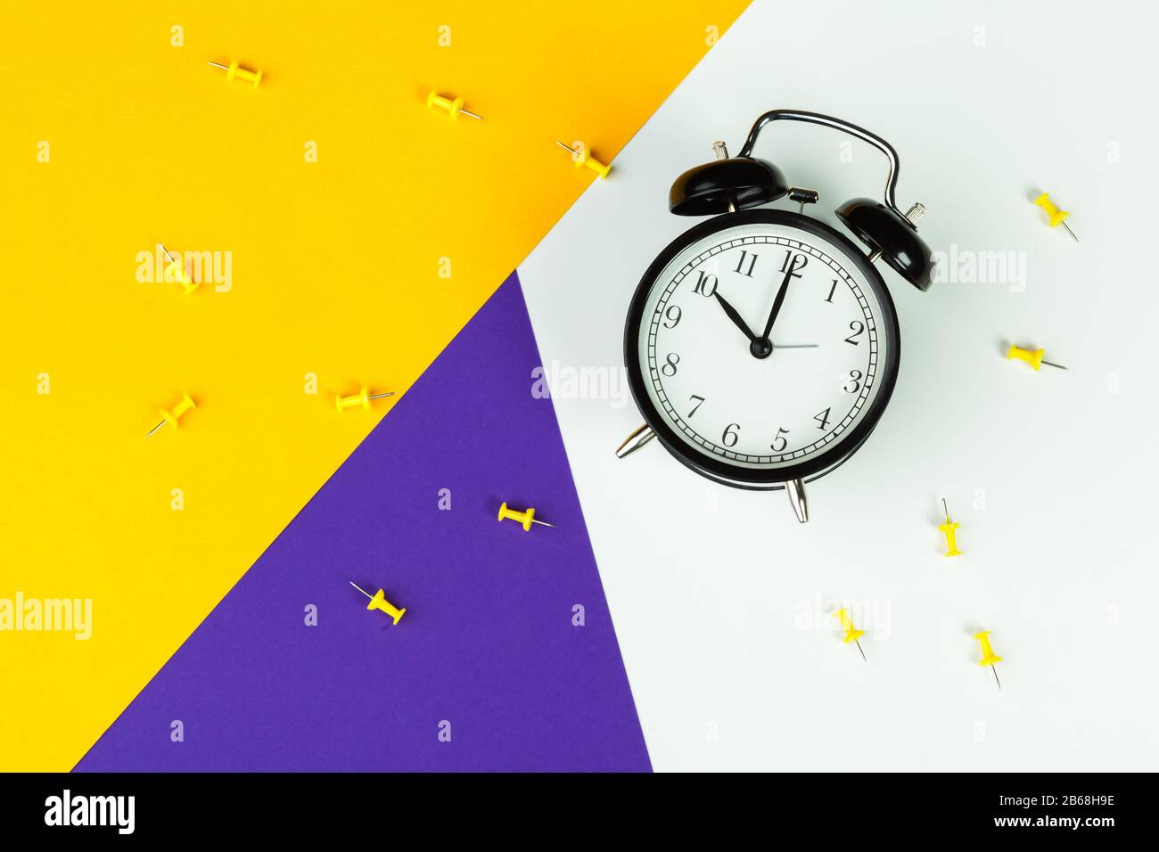 Black alarm clock on color block background, office interior Stock ...