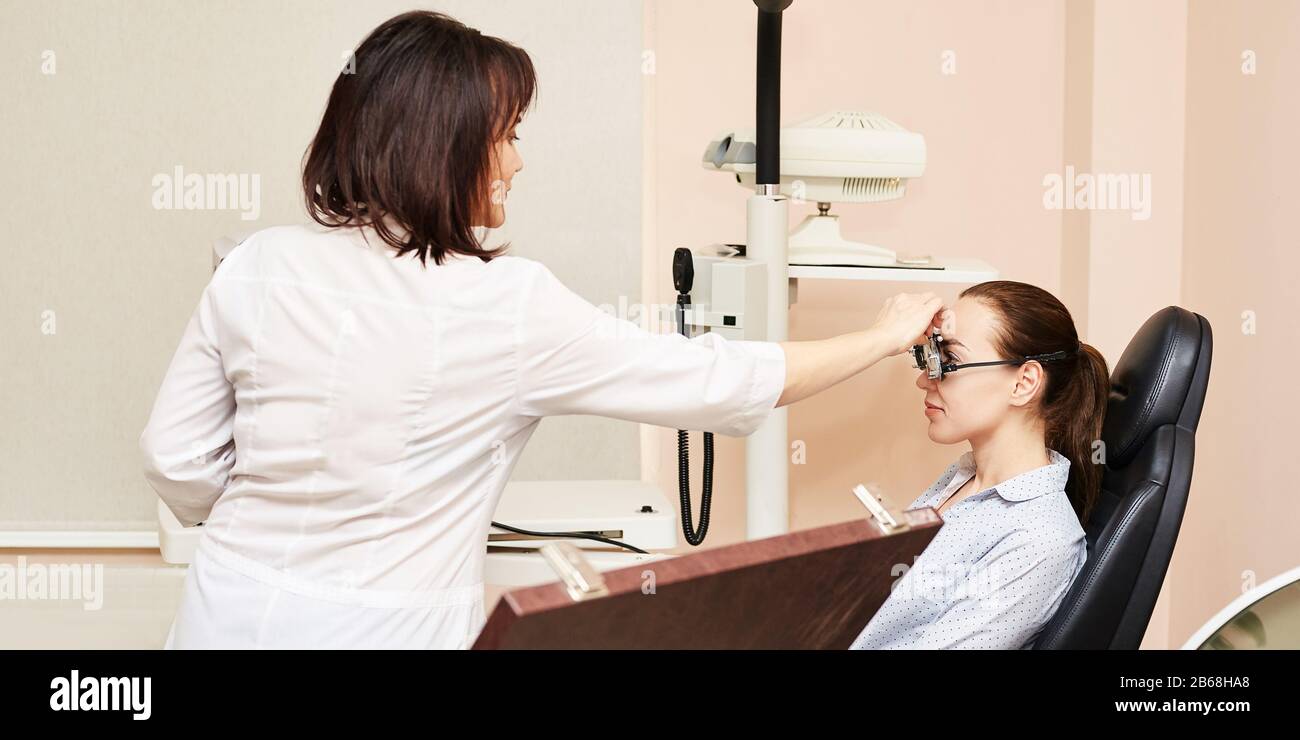 ophthalmologist doctor in exam optician laboratory with female patient ...
