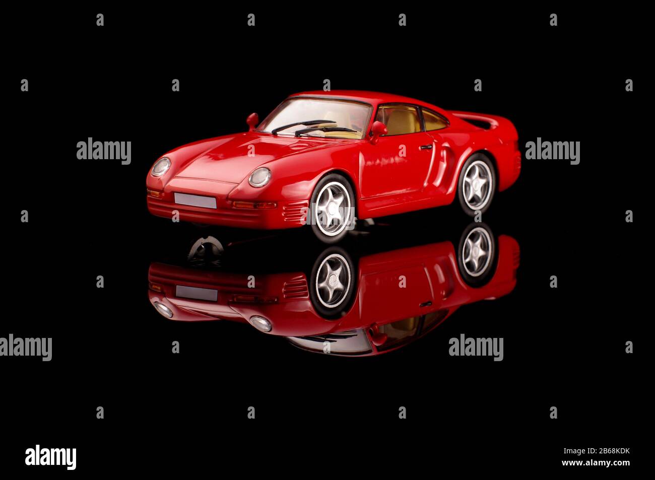 Red color modern die cast model car on the black reflective background ...