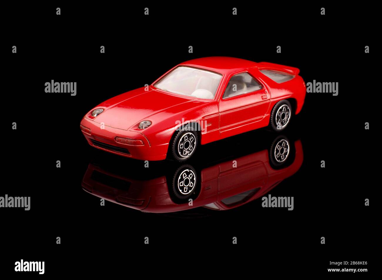 Red color modern die cast model car on the black reflective background ...