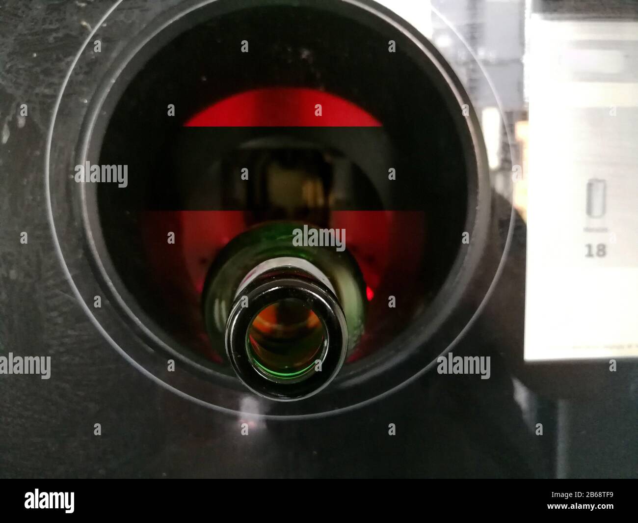 Green glass beer bottle close up inserted in the automatic reverse ...