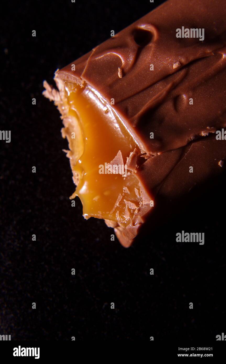 Bite off chocolate bar with tasty caramel macro close up isolated on ...