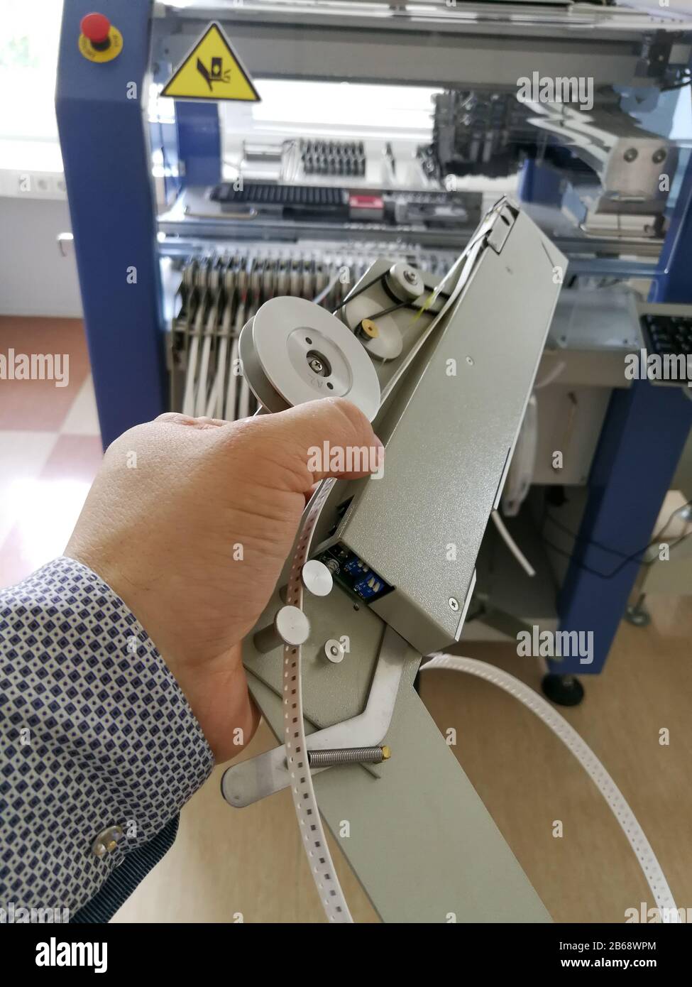 Pick and place machine feeder loaded with reel of electronics surface ...