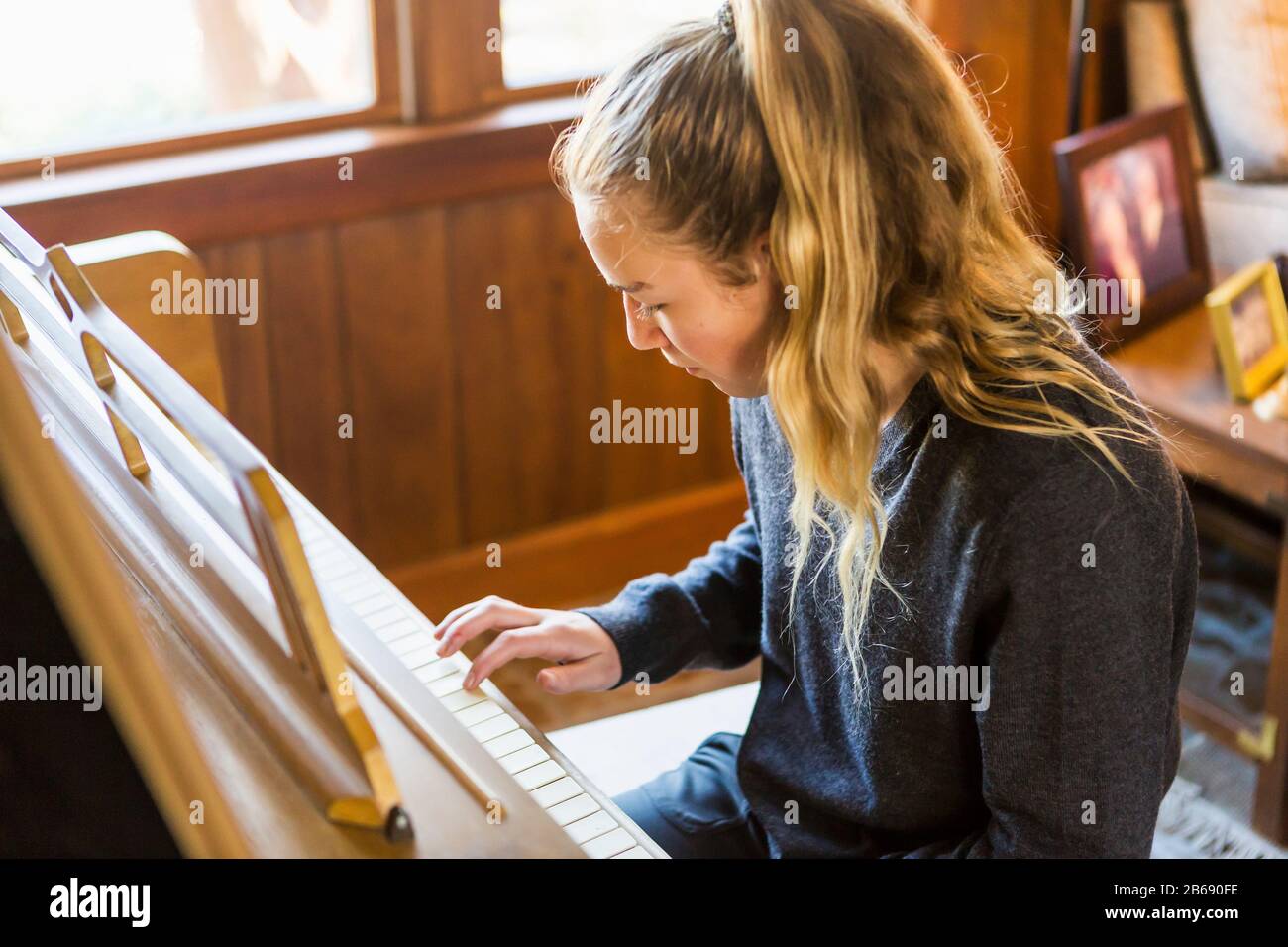 Teenage girl playing piano, practising Stock Photo - Alamy