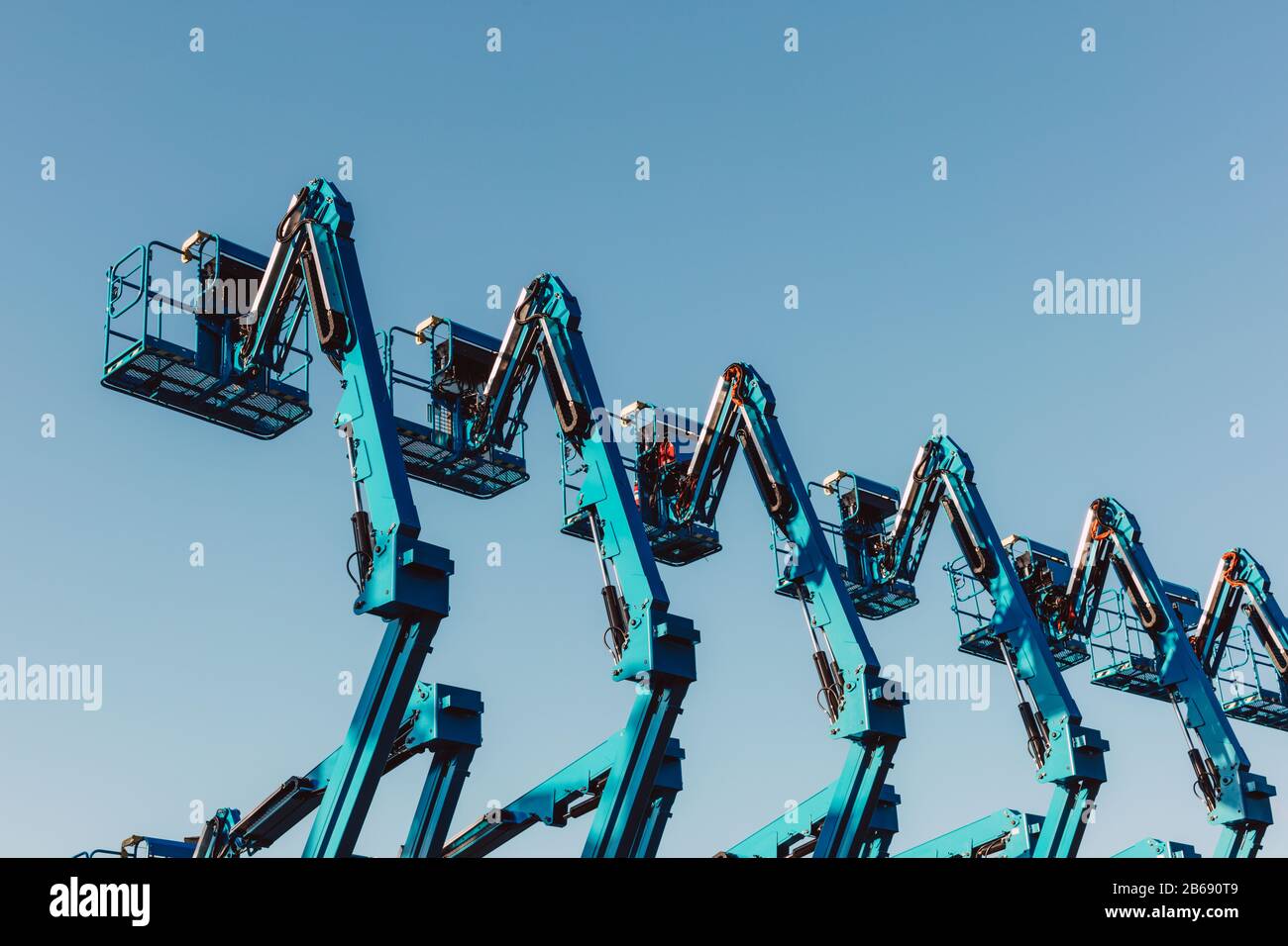 Row of hydraulic mobile cherry picker platforms at outdoor storage ...