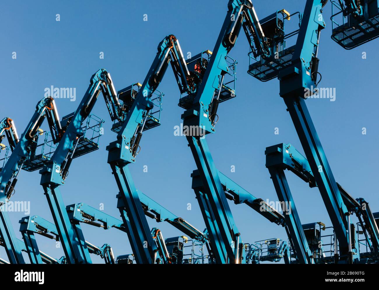 Row of hydraulic mobile cherry picker platforms at outdoor storage ...