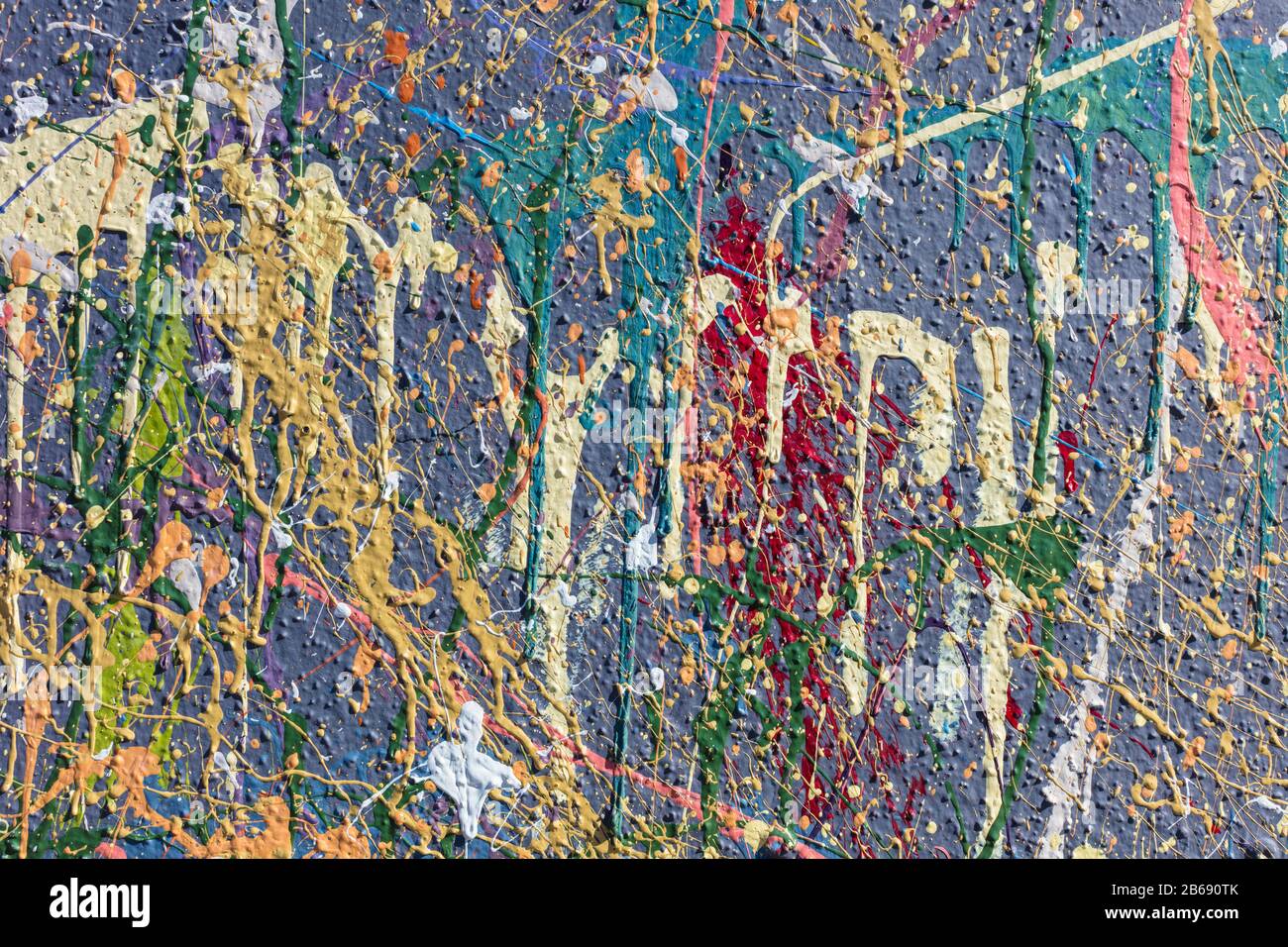 Colorful graffiti paint splattered and dripping on urban wall, close up ...