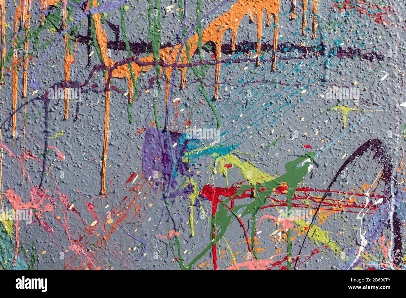 Colorful graffiti paint splattered and dripping on urban wall, close up ...
