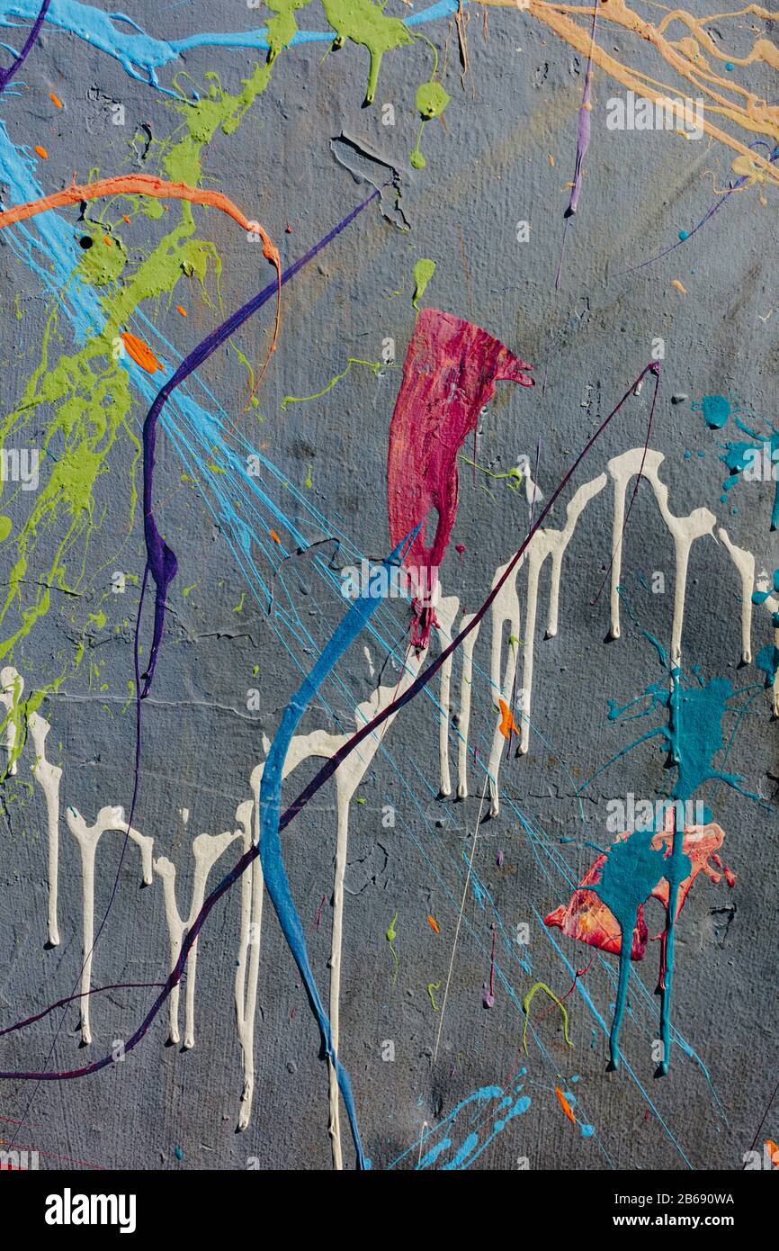 Colorful graffiti paint splattered and dripping on urban wall, close up ...