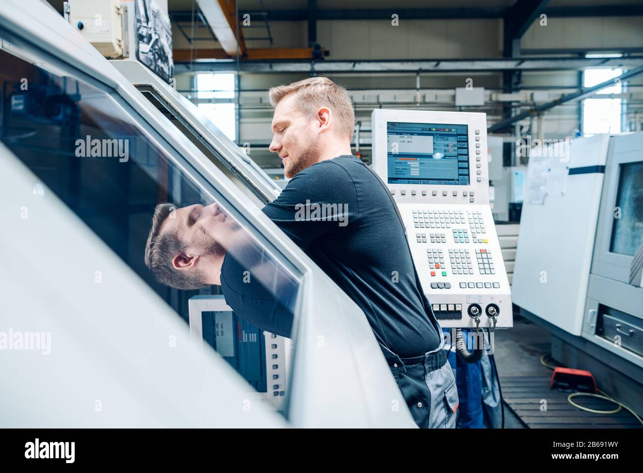 Worker resetting a cnc lathe machine in manufacturing factory Stock ...
