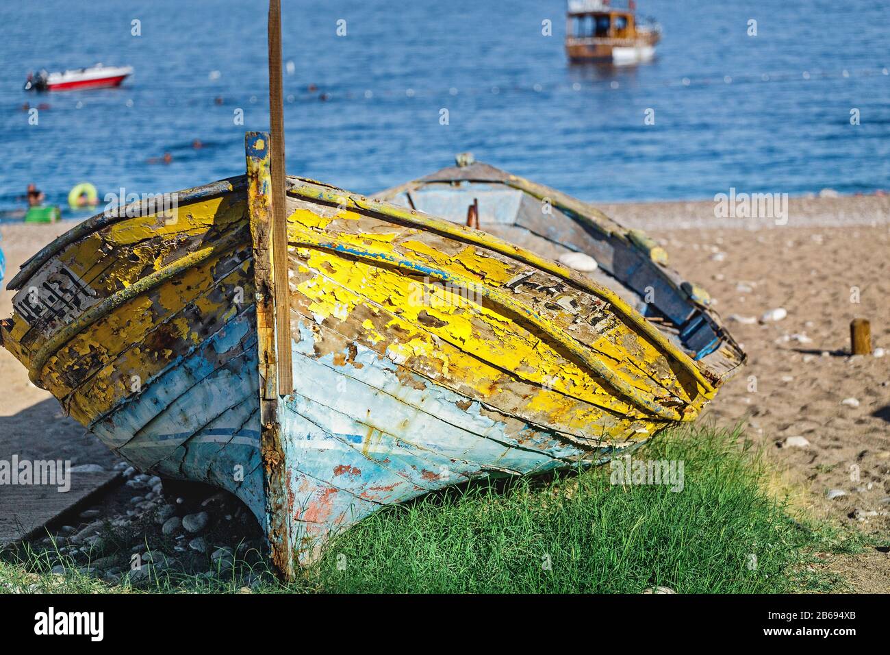 Colorful old fishing boat on a sea shore with cracked paint Stock Photo ...