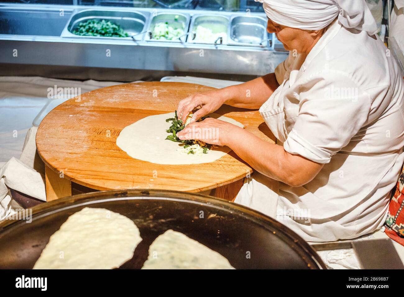 ISTANBUL, TURKEY - SEPTEMBER 10, 2017: Aged woman cooking street food ...