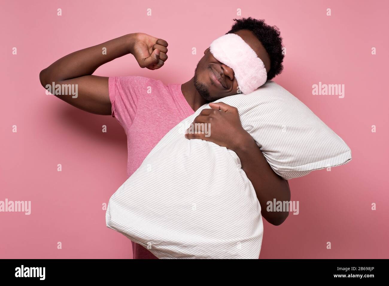 Young african american black man sleeping hugging a pillow wearing ... Young african american black man sleeping hugging a pillow wearing ...