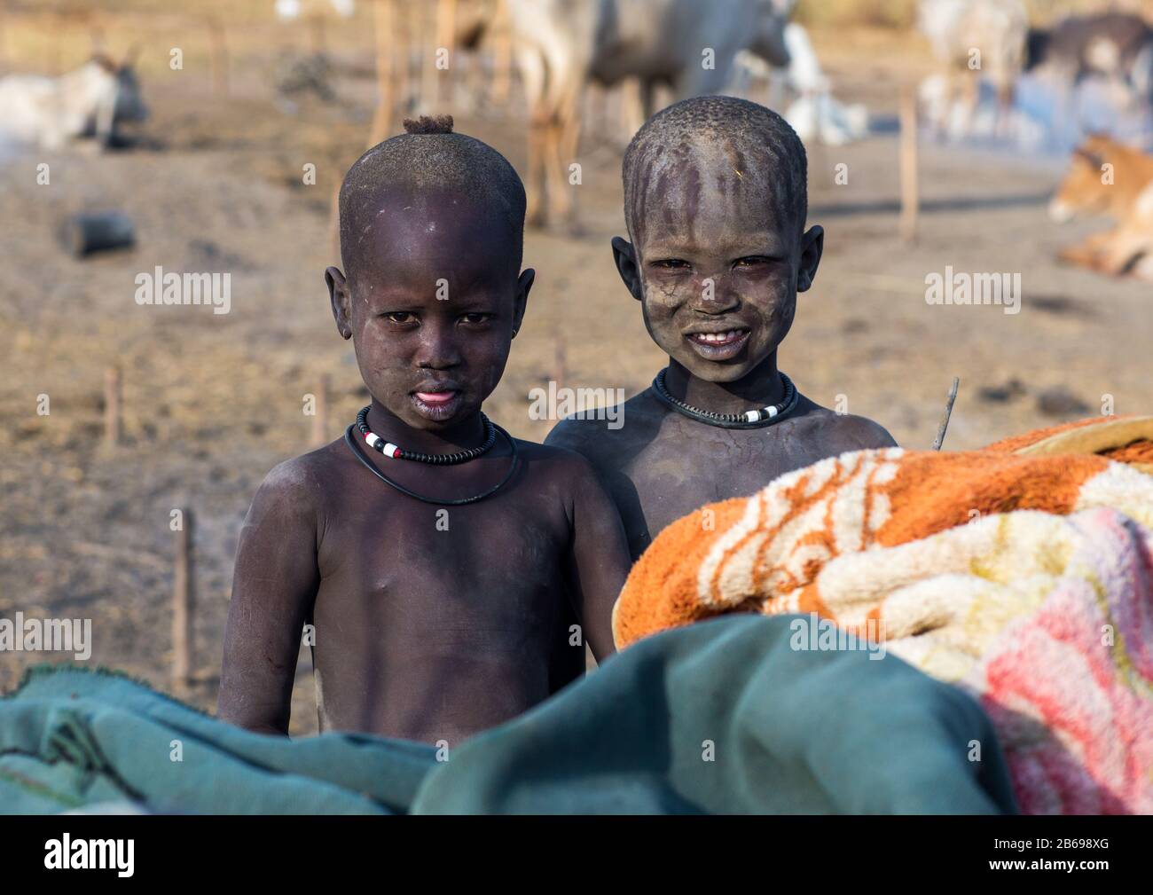Mundari tribe boys covered in ash to repel flies and mosquitoes in a ...