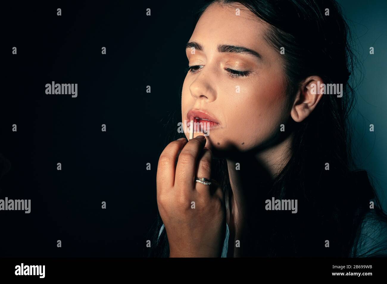 close up on the model face while the hand of the mua - makeup artist ...