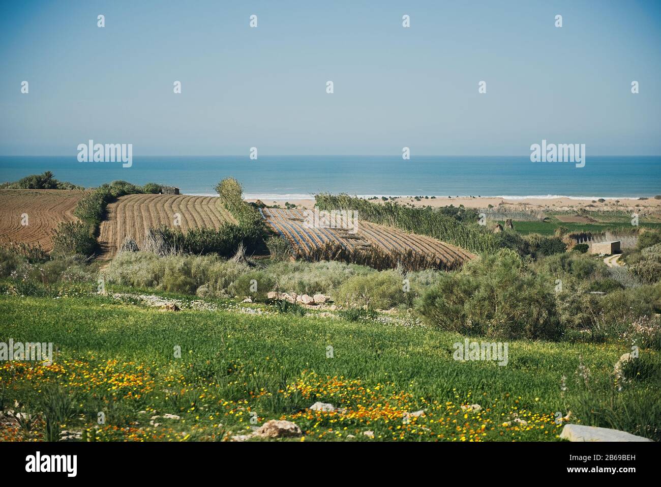Colorful straw house on farmland with blue ocean, sea and coastline in ...